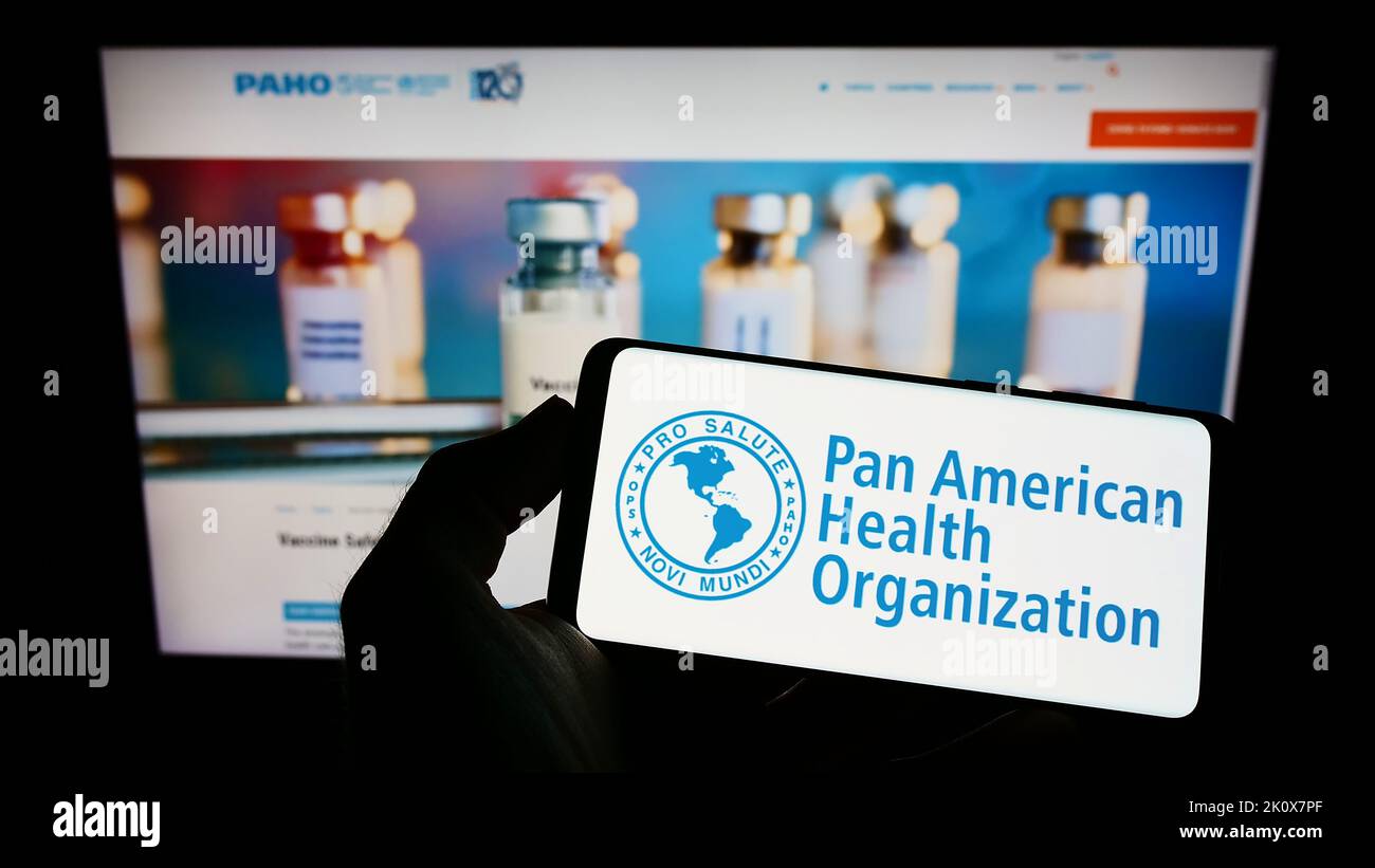Person holding mobile phone with logo of Pan American Health ...