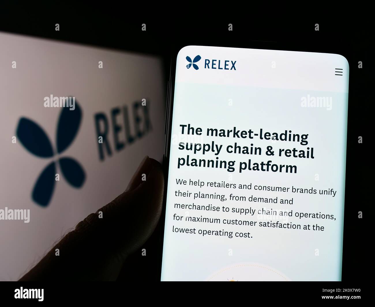 Person holding cellphone with webpage of Finnish software company RELEX ...