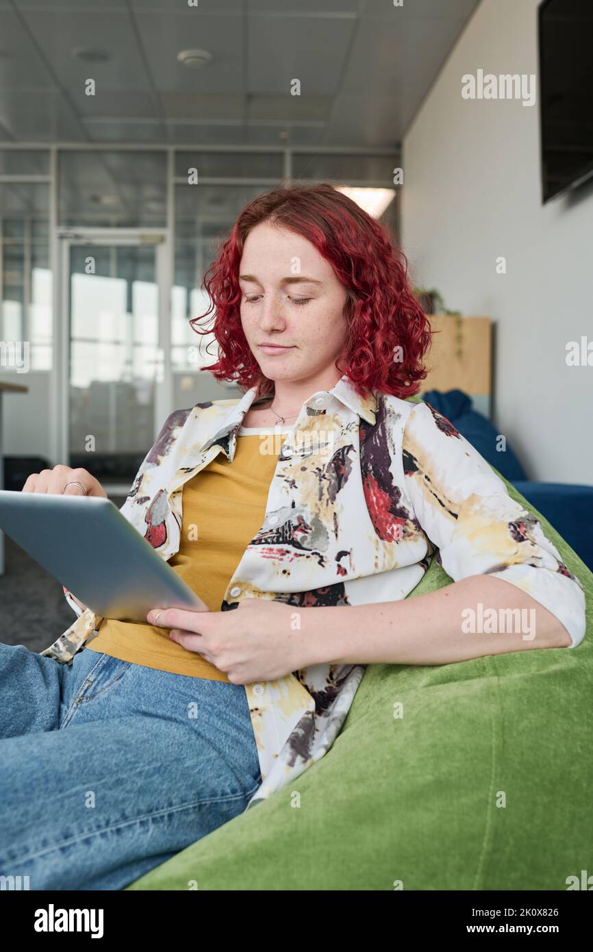 Young contemporary white collar worker in casualwear scrolling in ...