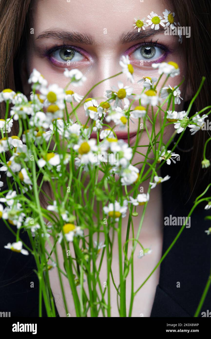 Female with long brown hair цшер bouquet of daisies. Woman with brows ...