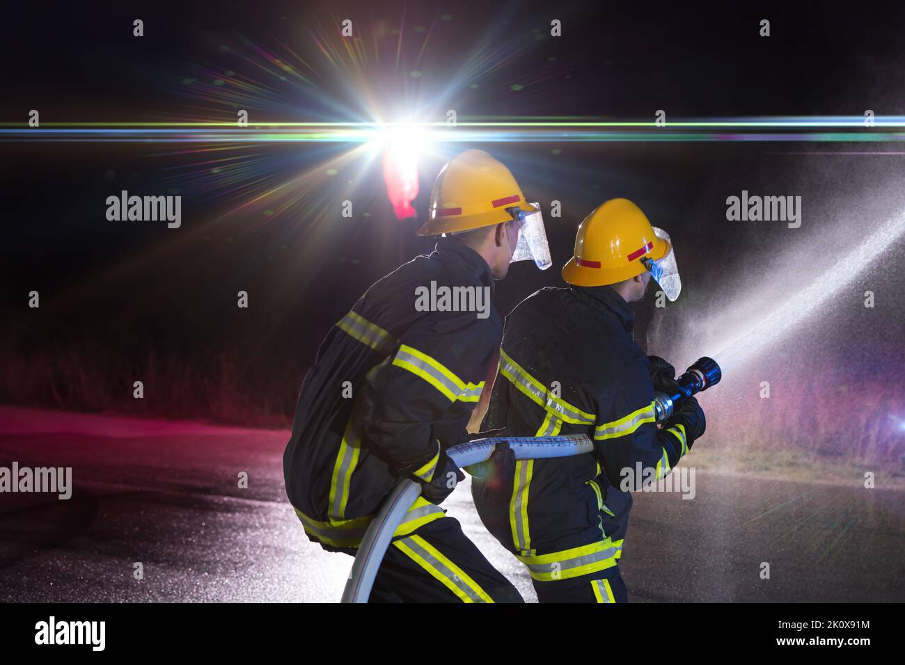 Firefighters use a water hose to eliminate a fire hazard. Team of ...