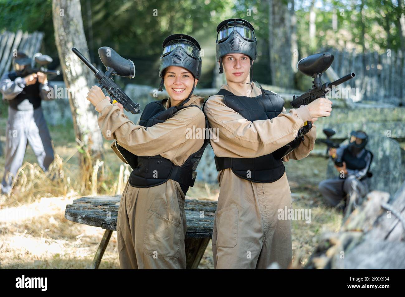 Cheerful boy and girl paintball players holding guns and posing Stock ...