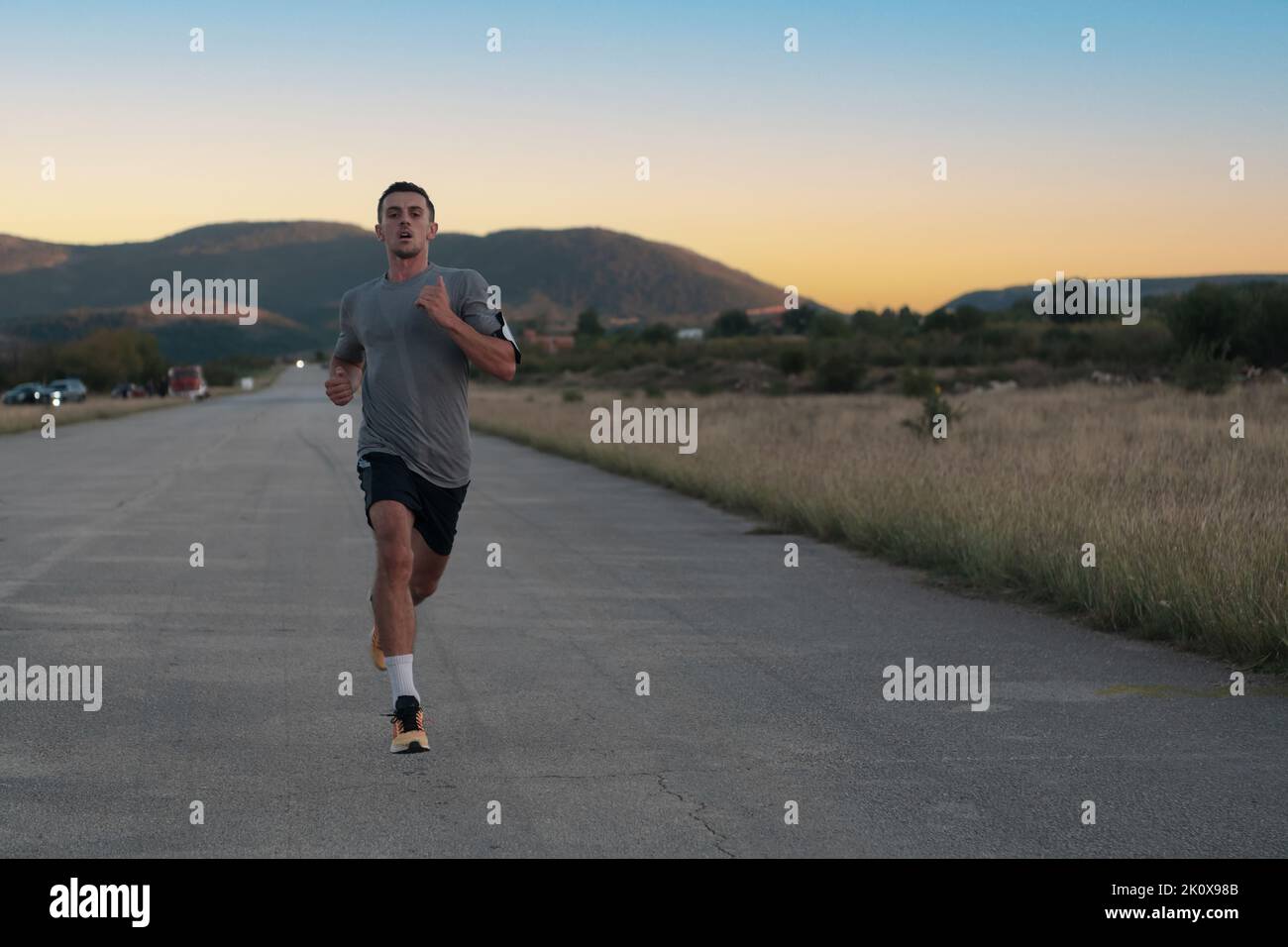 Sport couple looking at a smartwatch while standing on the country road ...