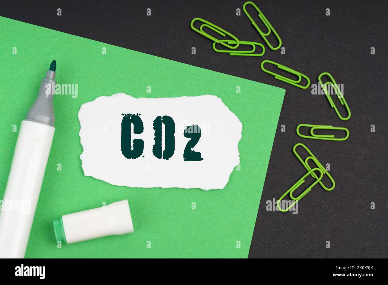 Ecology concept. On a black background, a marker, paper clips, a sheet ...