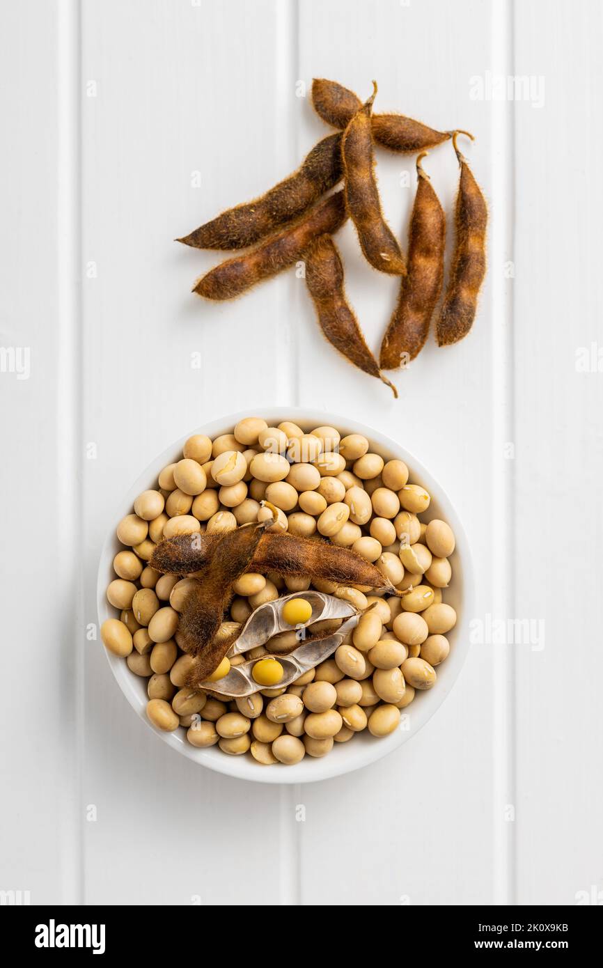 Soy beans. Dried soybean pod in bowl on the white table. Top view Stock ...