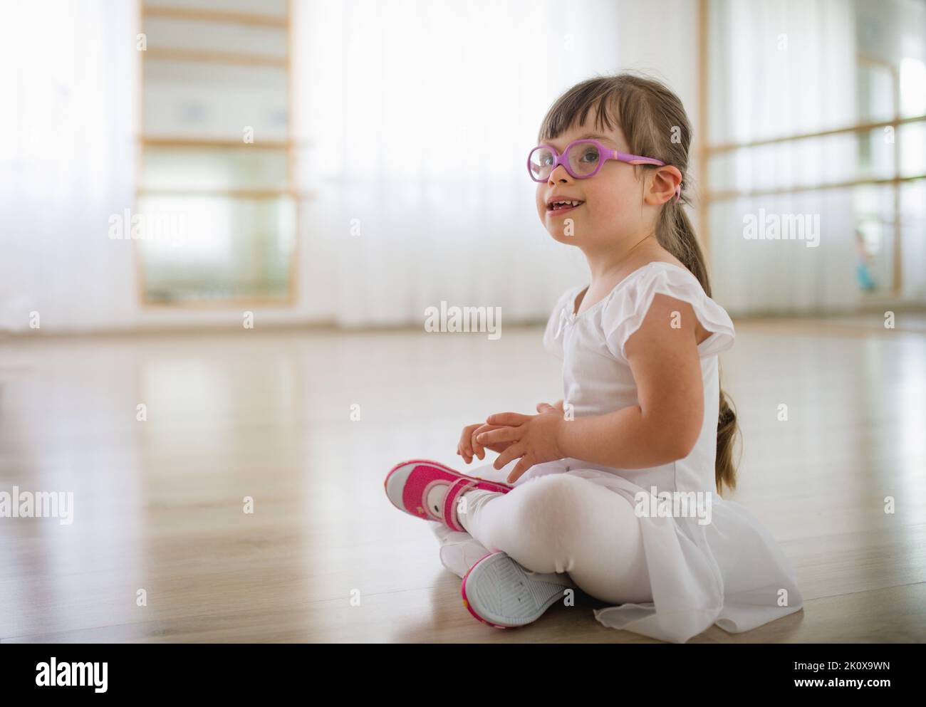 Little girl with down syndrome at ballet class in dance studio,sitting ...