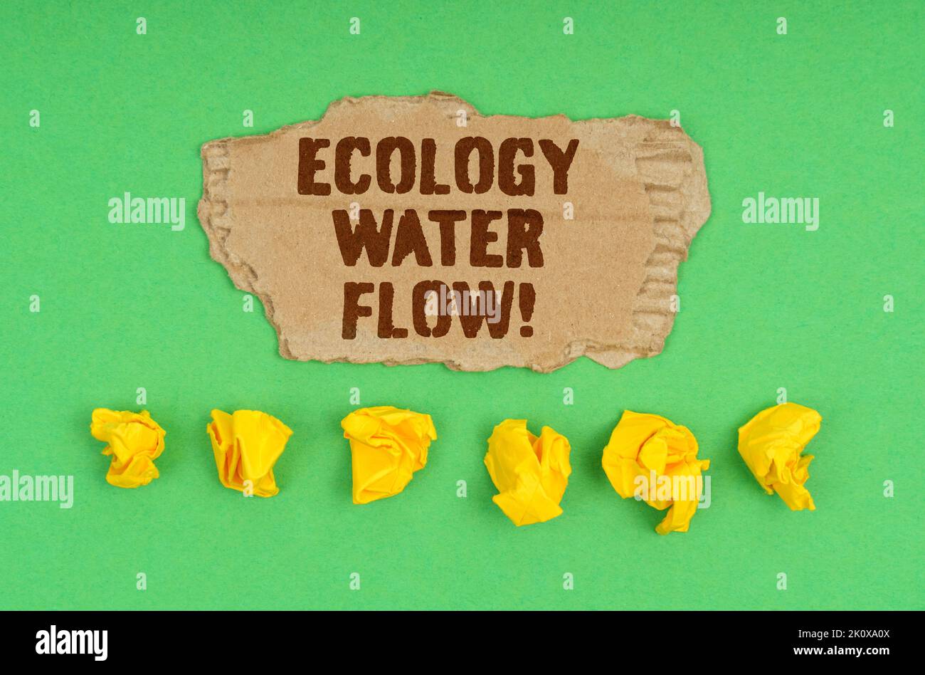 Ecology concept. On a green background, crumpled yellow paper and a ...