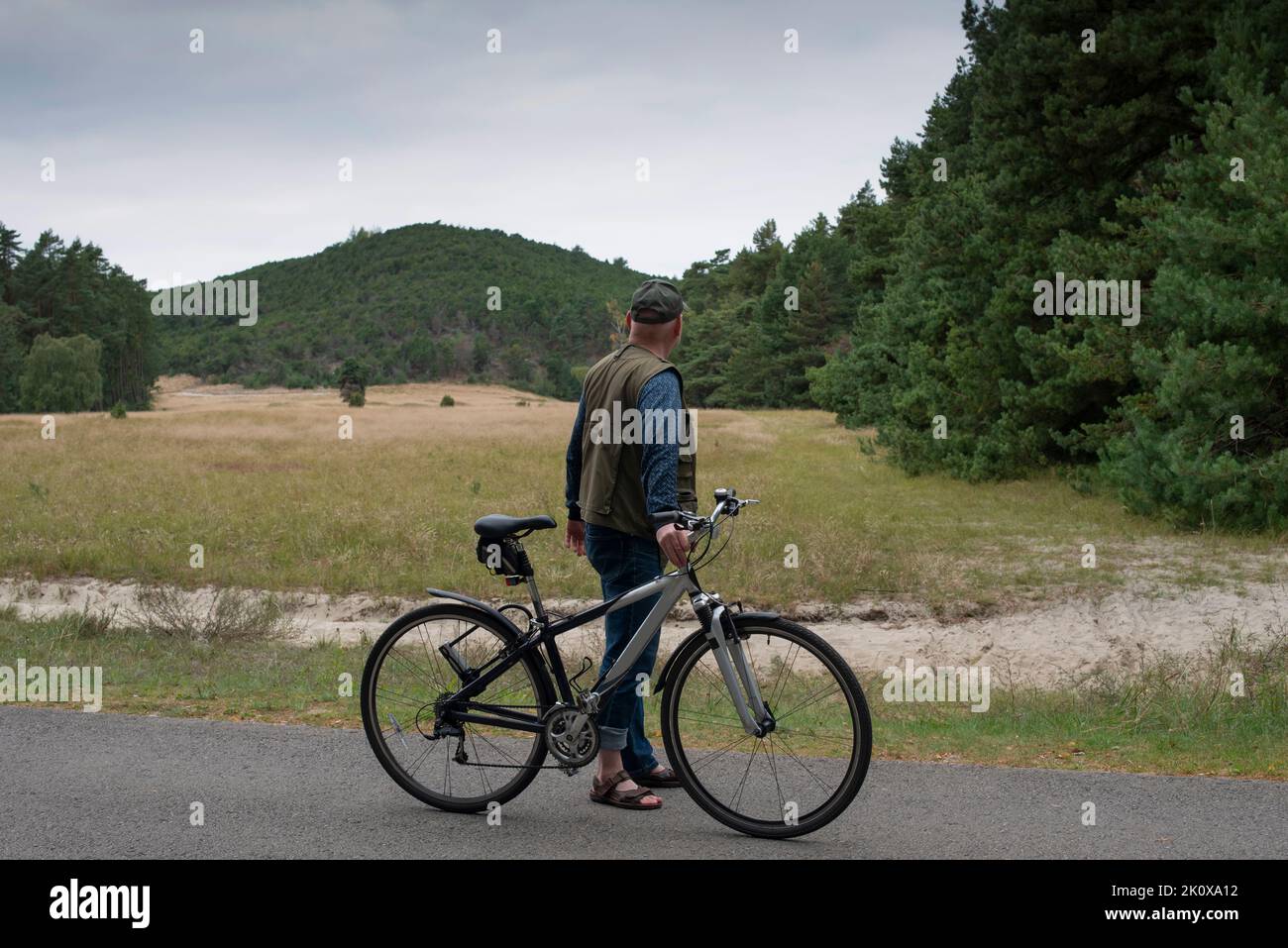 A man with bicycle on recreational cycle path looking at the hill Stock ...
