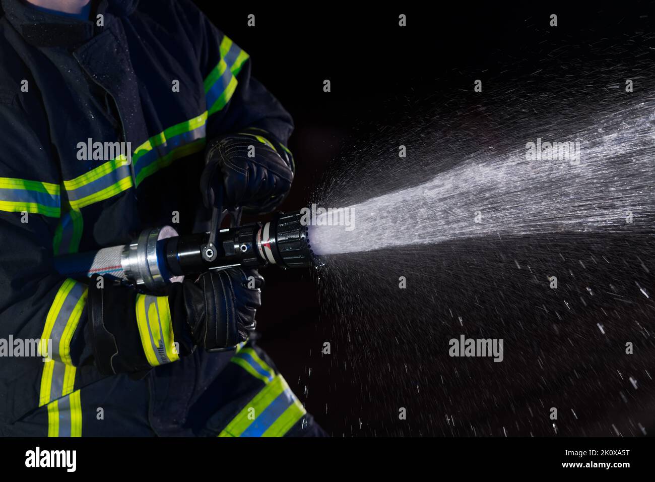 Firefighters use a water hose to eliminate a fire hazard. Team of ...