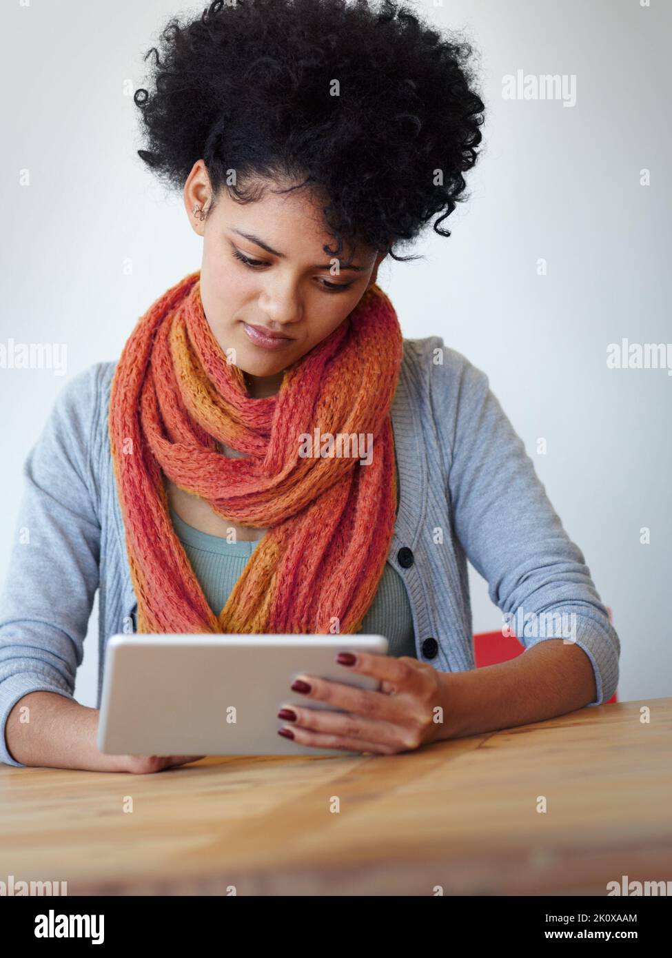 Fascinated by her new tablet. An attractive young woman sitting with ...