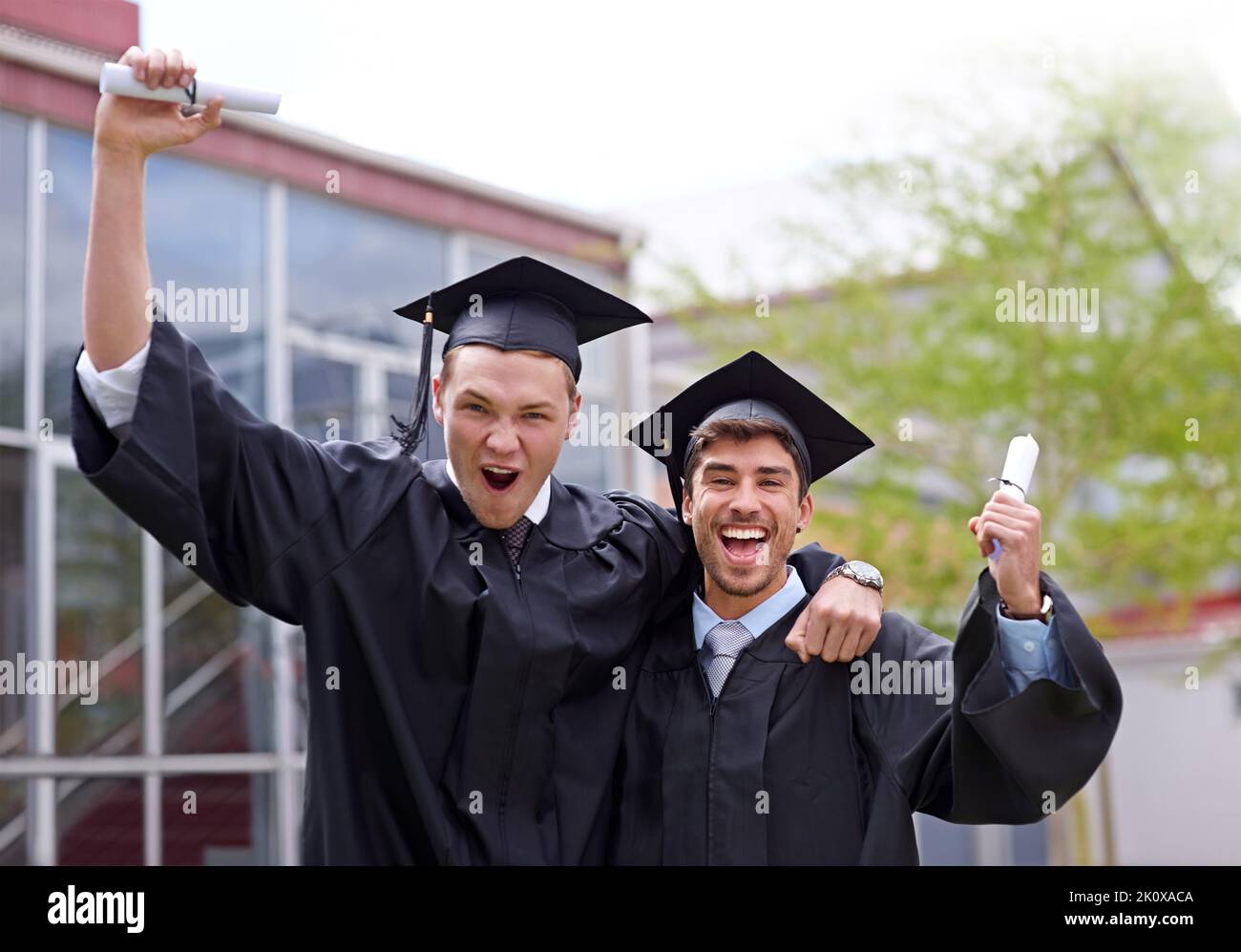 Moving on. two guy friends celebrating on their graduation day Stock ...