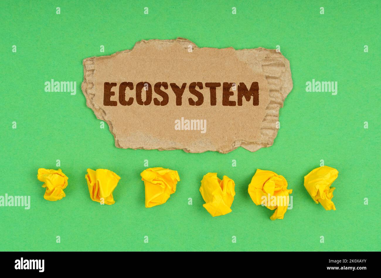Ecology concept. On a green background, crumpled yellow paper and a ...