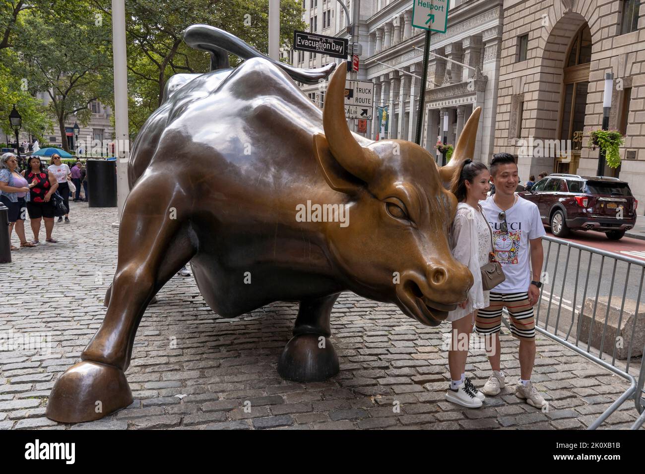 NEW YORK, NEW YORK - SEPTEMBER 13: People pose with the Charging Bull (Wall Street Bull) in the ...