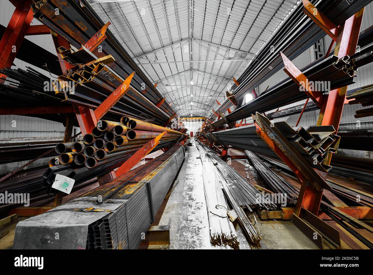 Aisle between racks with rolled metal products in store Stock Photo - Alamy