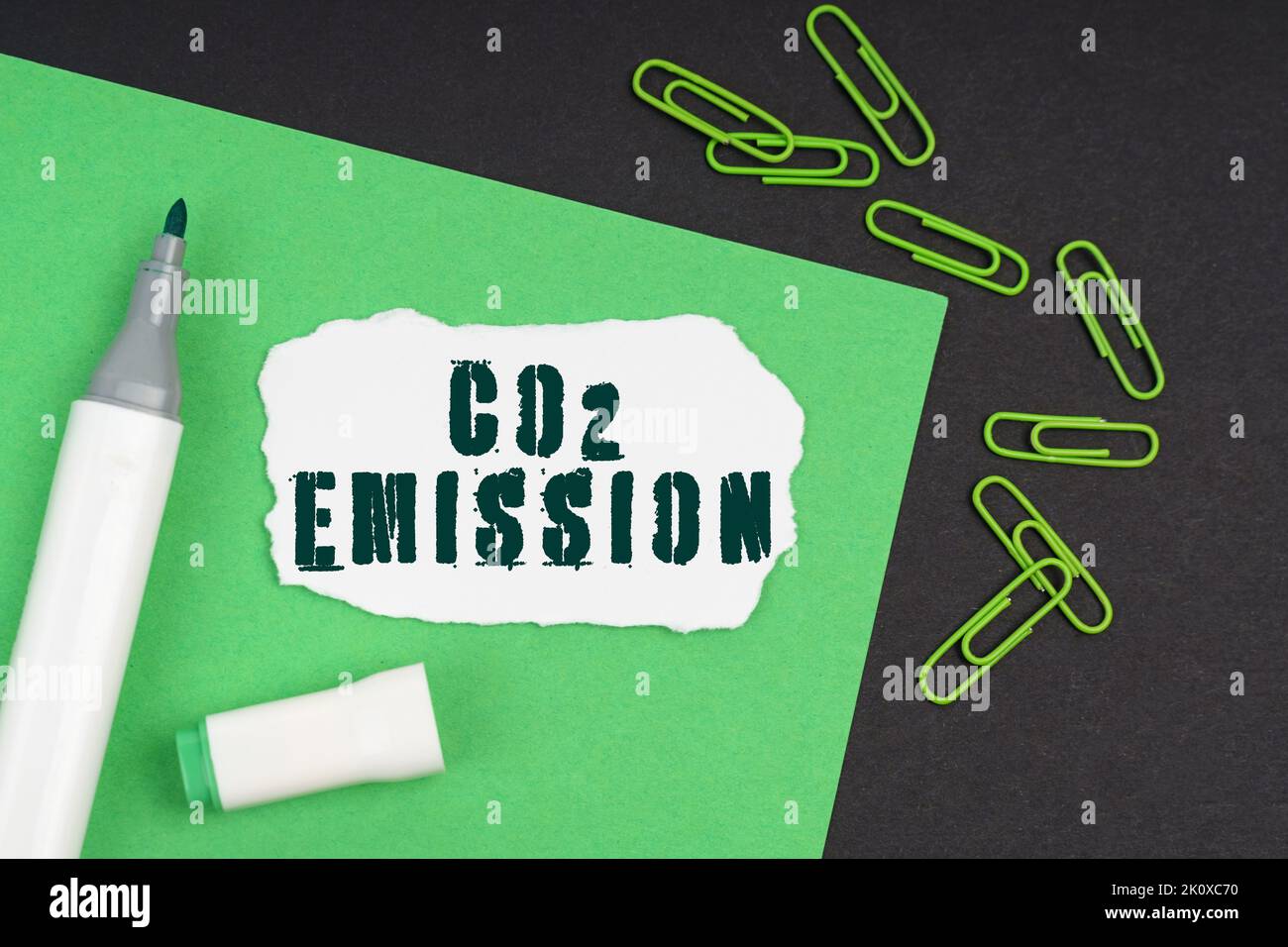 Ecology concept. On a black background, a marker, paper clips, a sheet ...