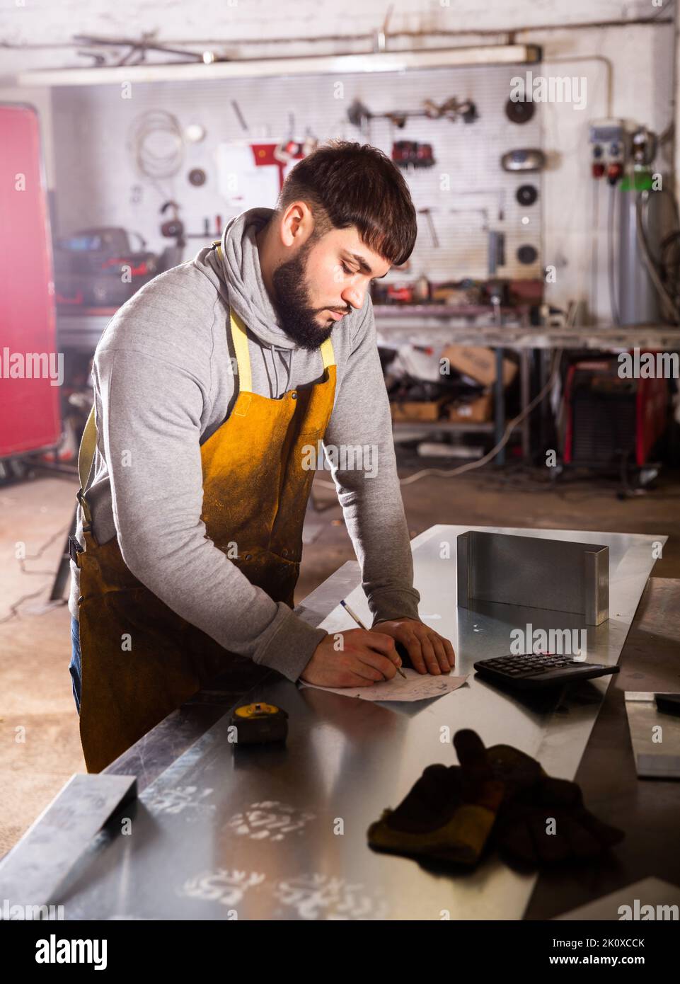 Young man engineer calculation size of material Stock Photo - Alamy