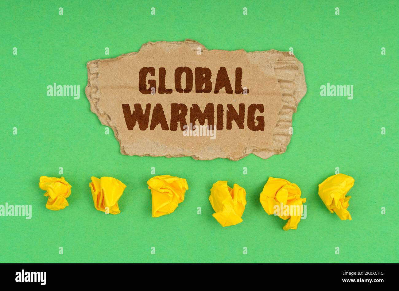 Ecology concept. On a green background, crumpled yellow paper and a ...