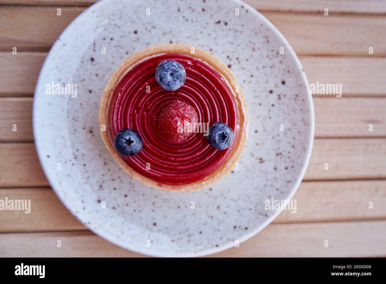 French blueberry and raspberry berries tart on white ceramic plate ...