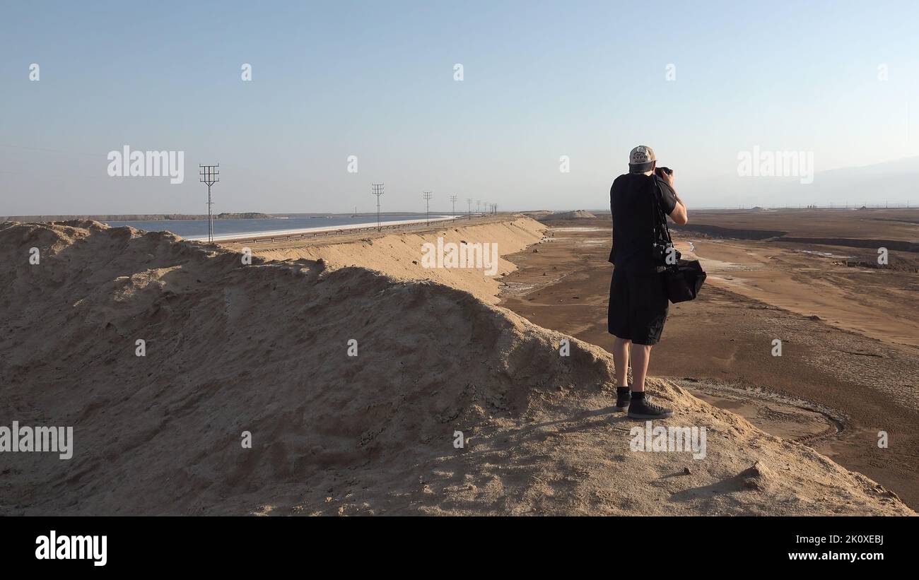 A photographer takes photos from the salt wall barrier along the border ...