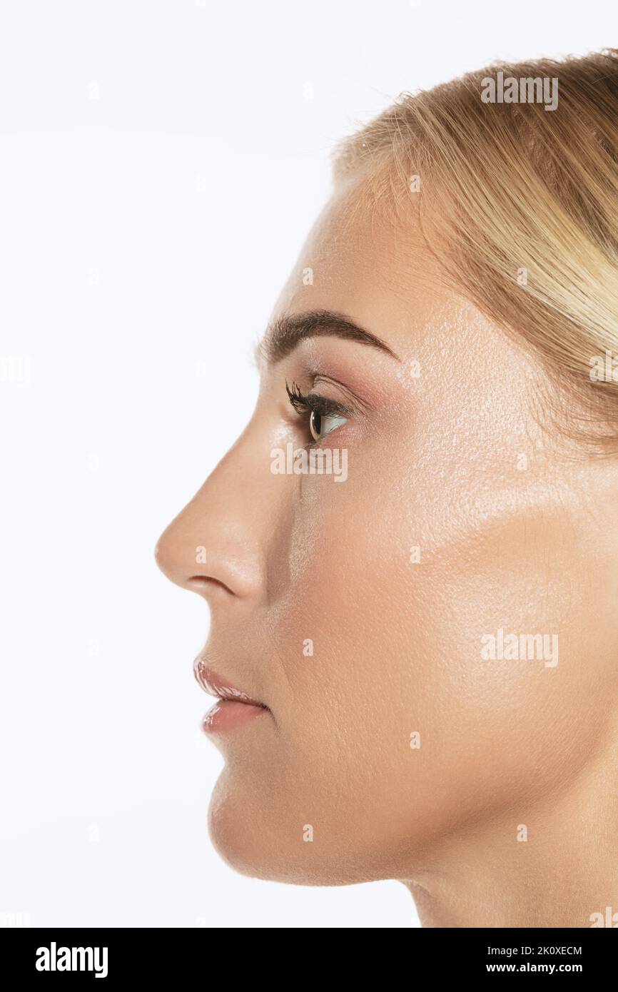 Profile view of beautiful young woman on white studio background ...