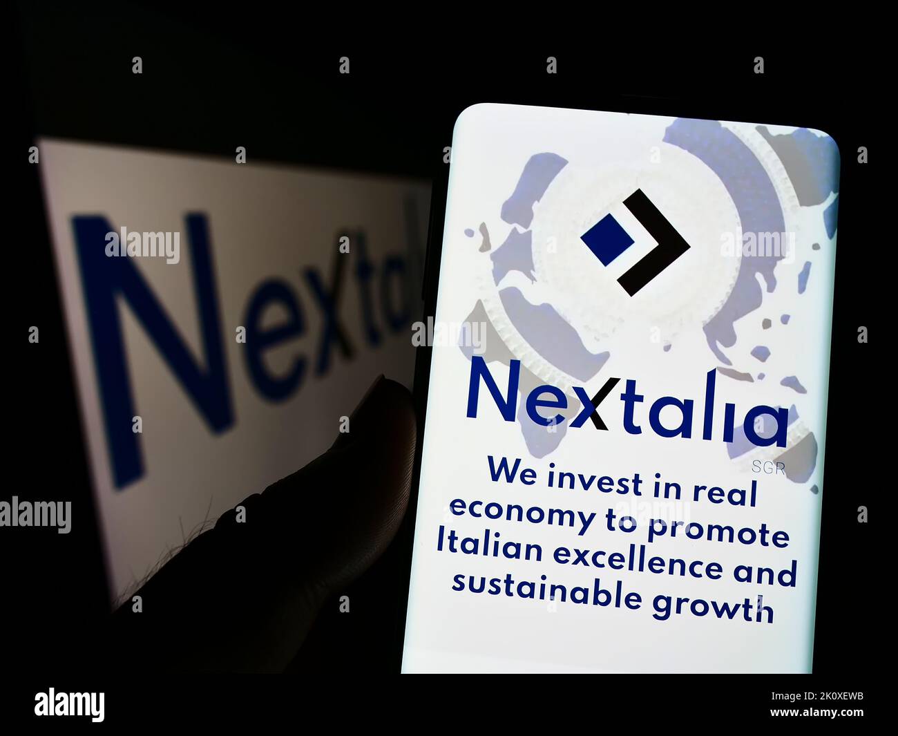 Person holding cellphone with website of Italian investment company ...