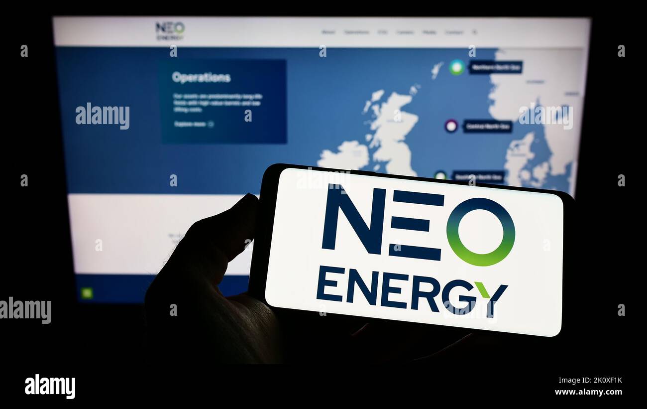 Person holding smartphone with logo of British oil and gas company NEO ...
