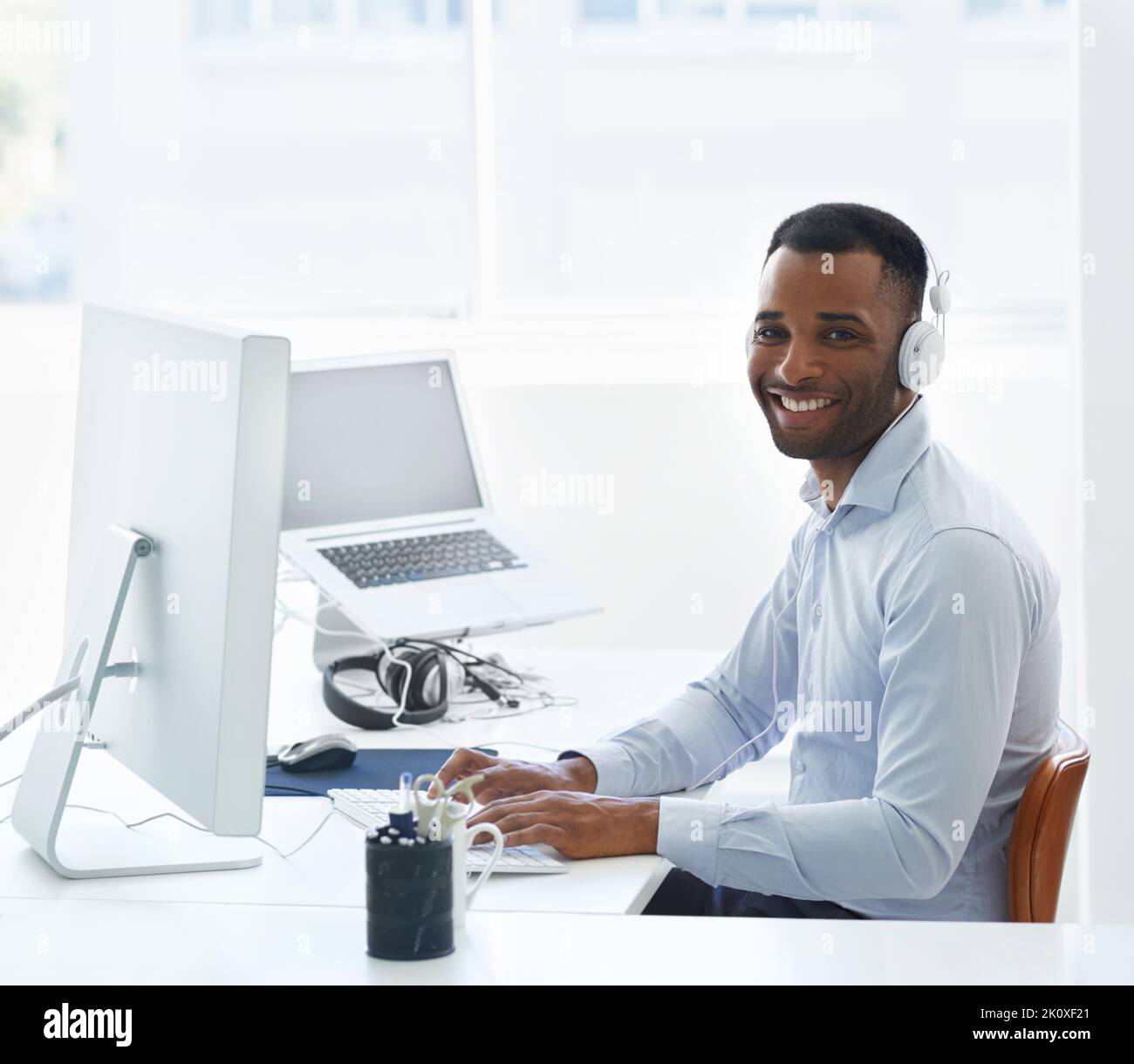 Enjoying his playlist at work. A handsome young african american ...