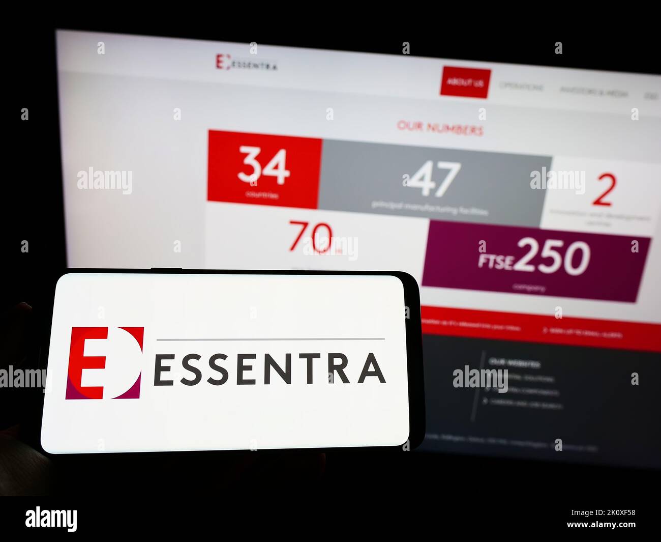 Person holding mobile phone with logo of British manufacturing company ...