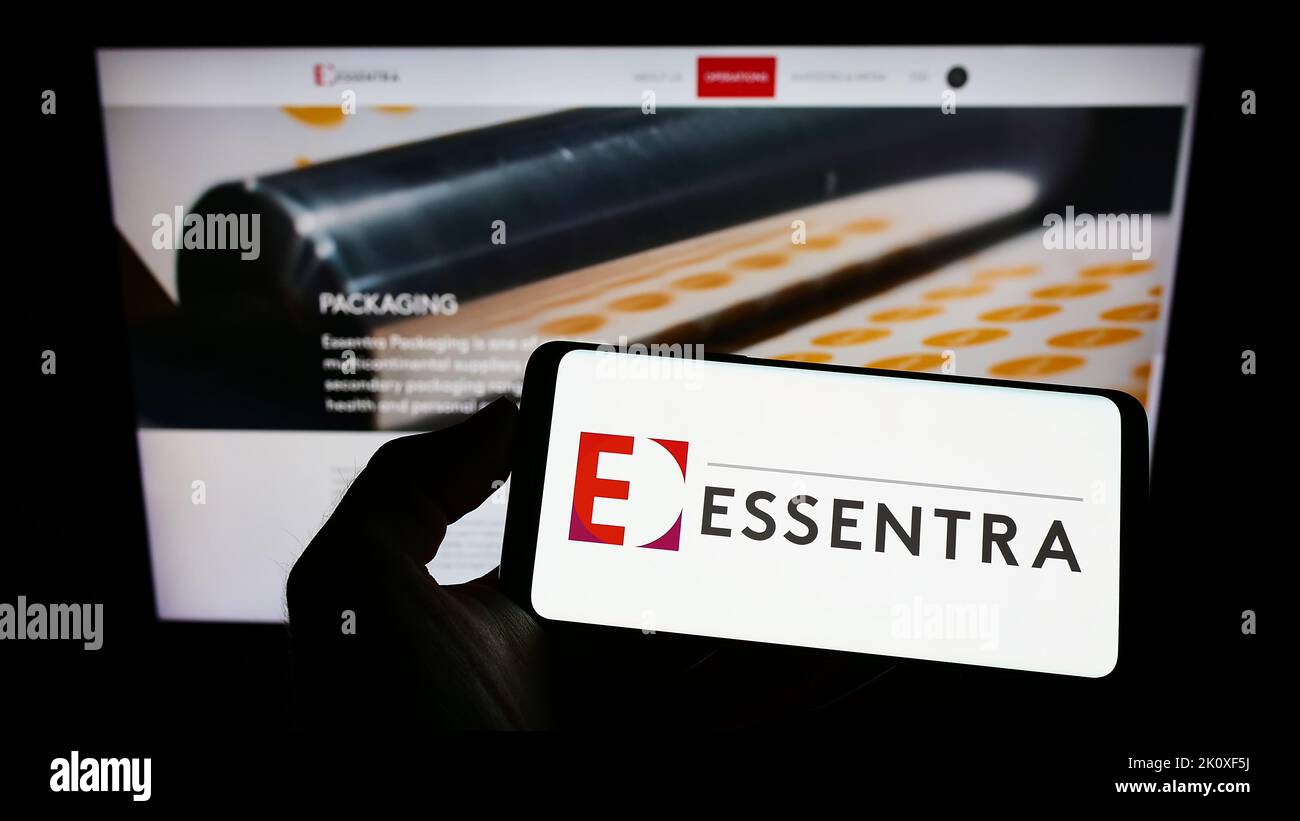 Person holding cellphone with logo of British manufacturing company Essentra plc on screen in ...