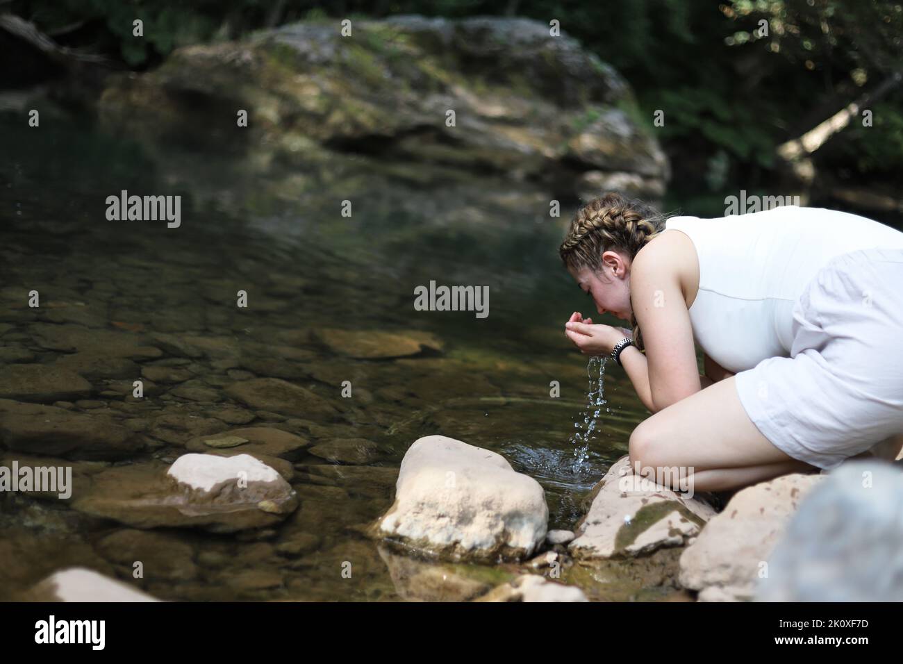 A closeup of a girl washing her face in a river Stock Photo - Alamy