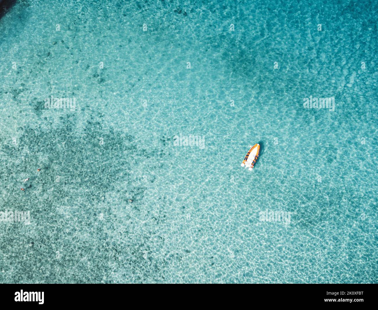 an aerial view of blue ocean with a boat floating Stock Photo - Alamy