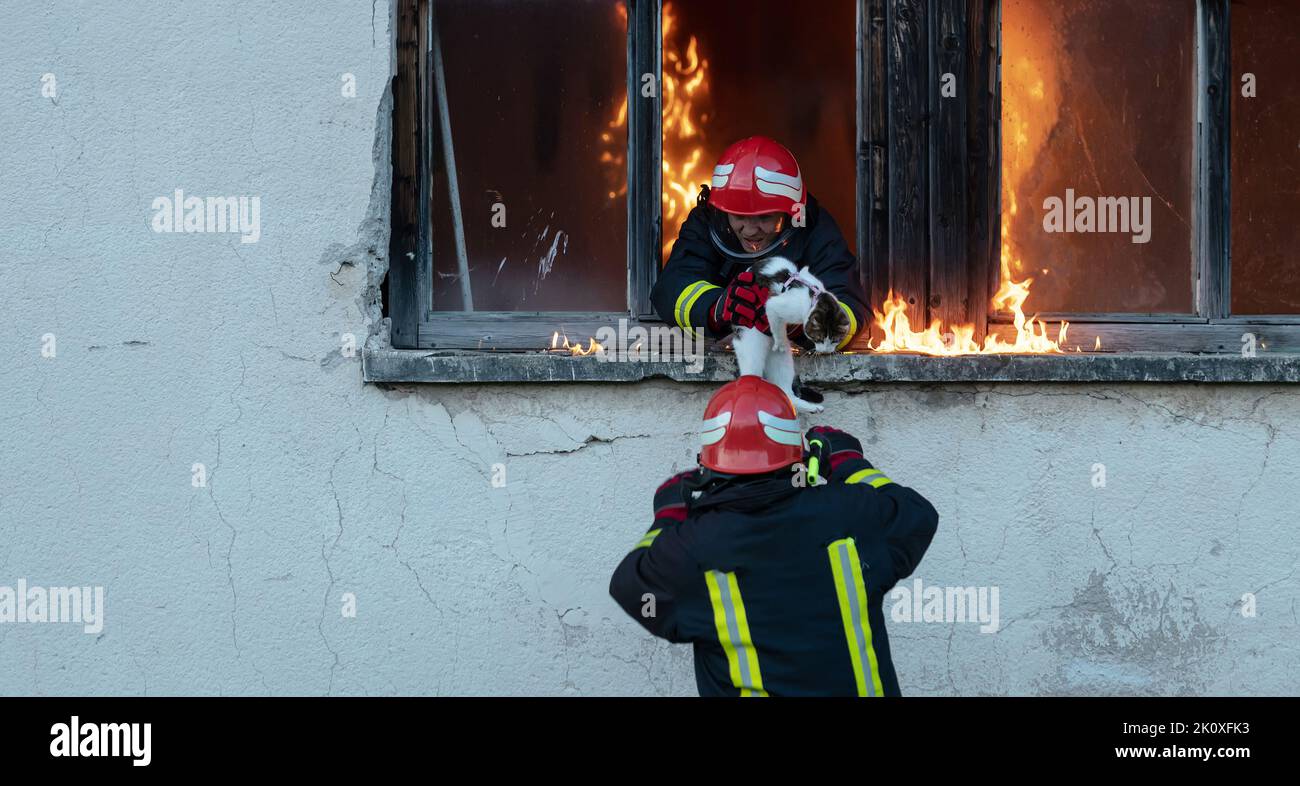 Firefighter hero carrying baby girl out from burning building area from ...