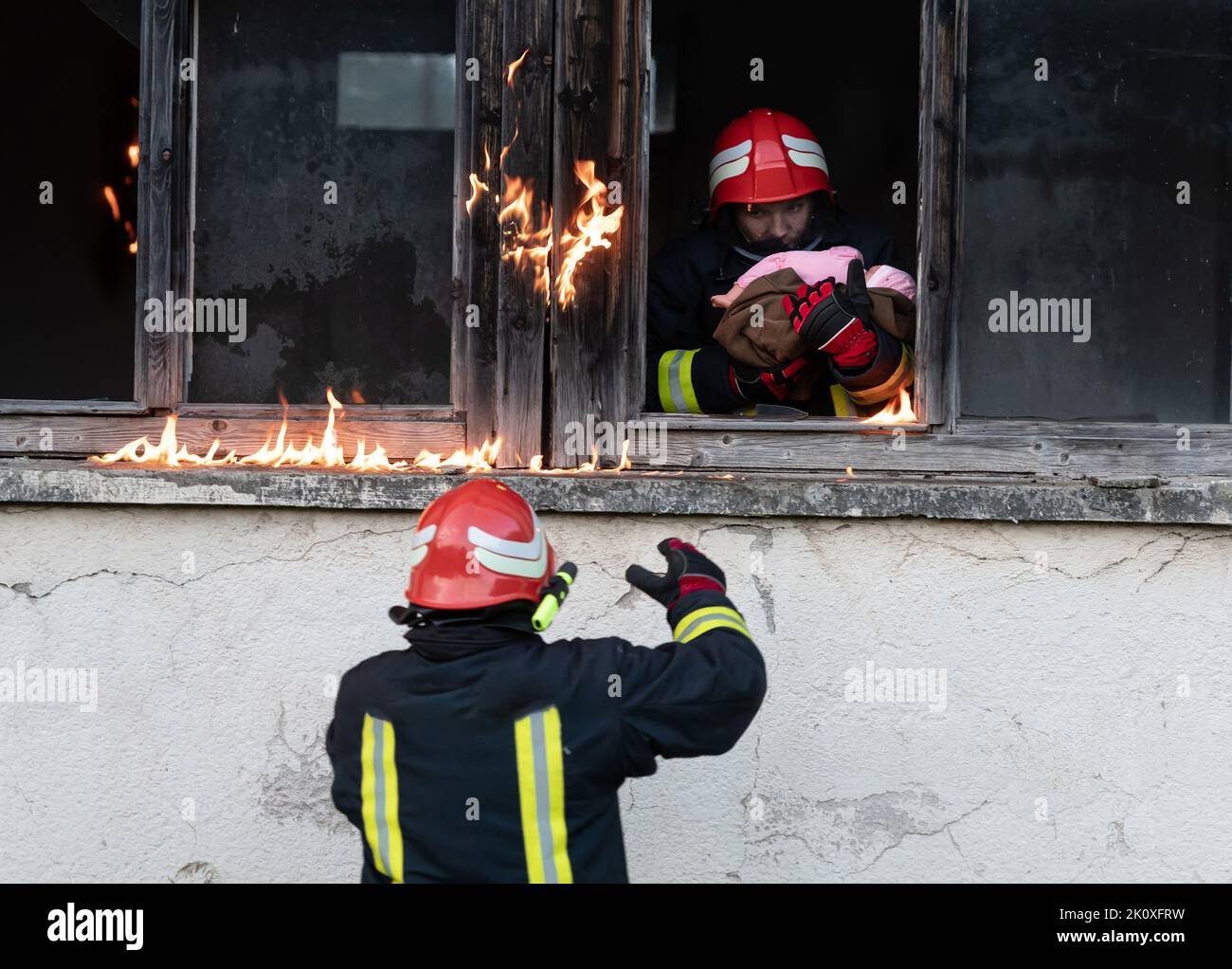 Firefighter hero carrying baby girl out from burning building area from ...