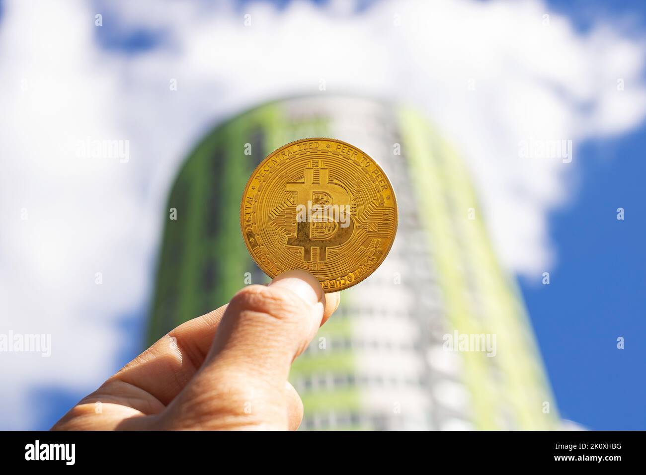 Bitcoin on the backdrop of a modern tall building Stock Photo - Alamy