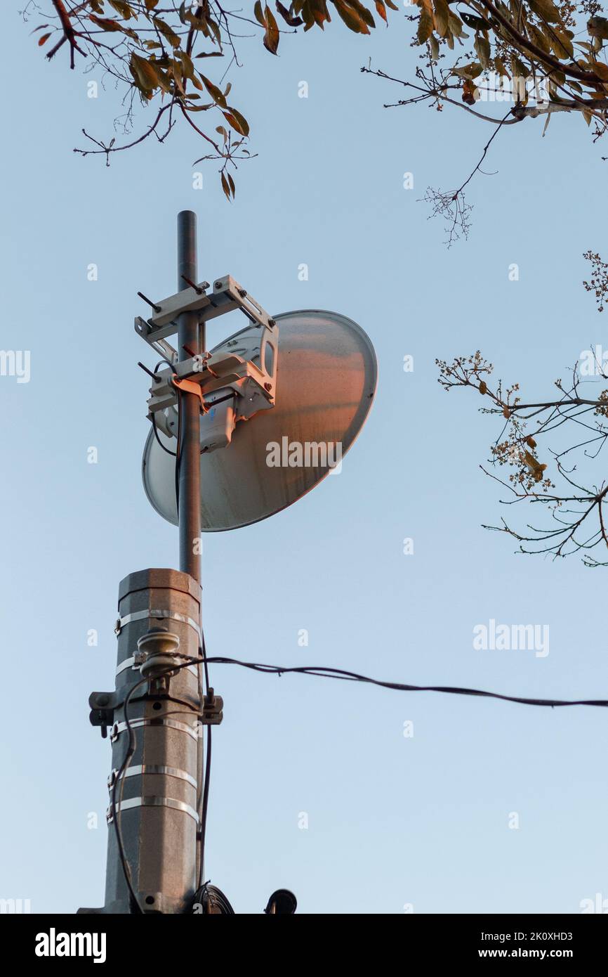 A vertical low angle shot of a radio relay antenna against a blue sky ...