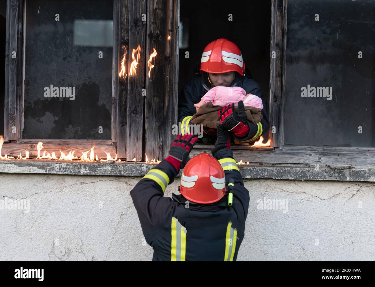 Firefighter hero carrying baby girl out from burning building area from ...