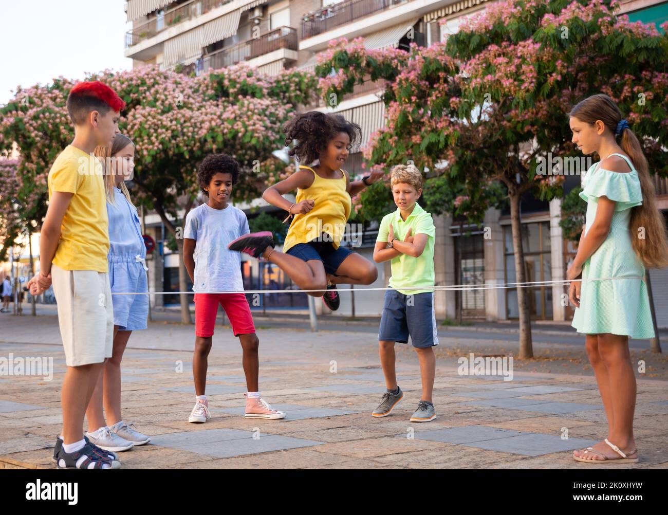 Kids playing with chinese jumping rope outdoors Stock Photo - Alamy