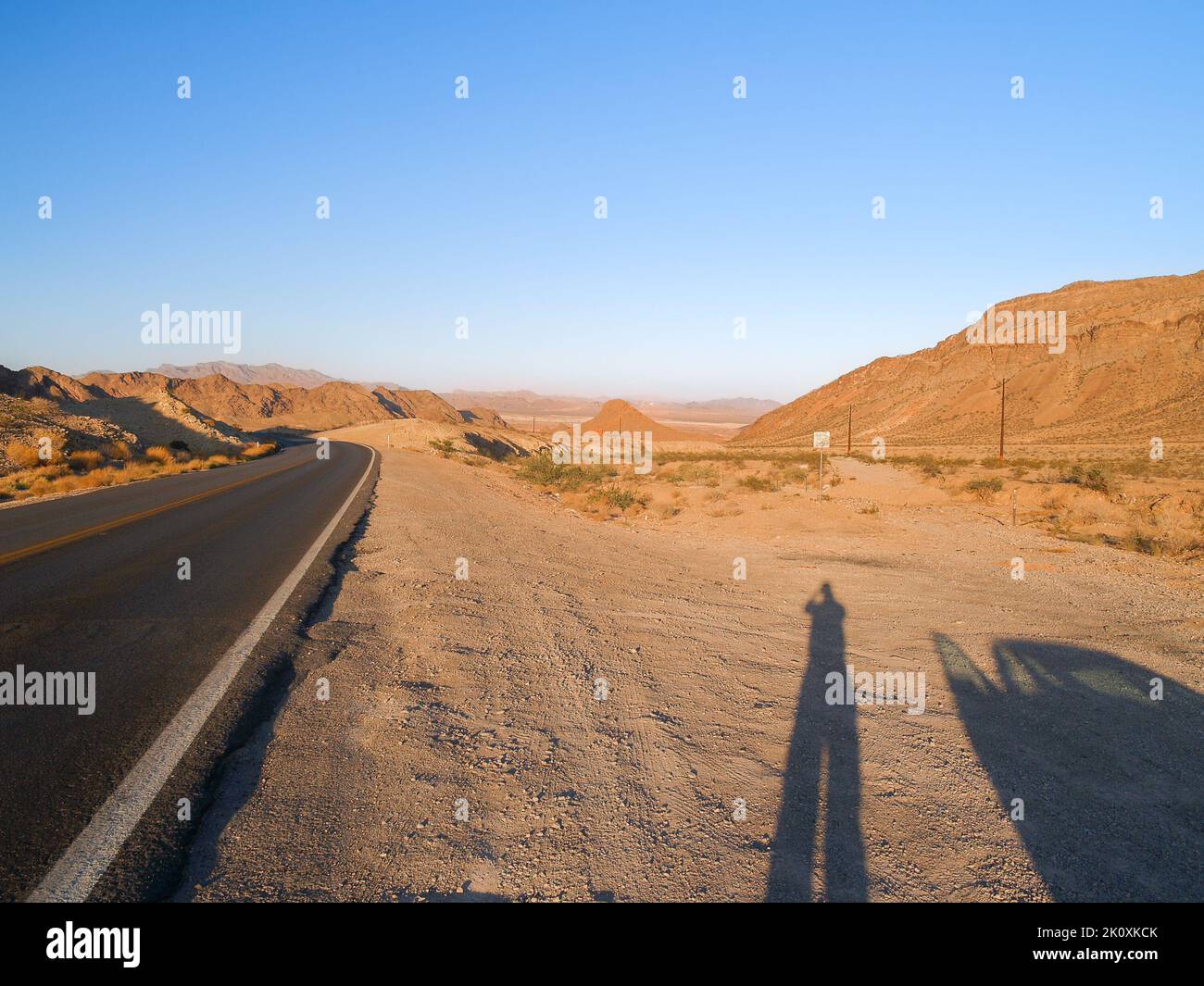 Long shadows of tourist stopped to take in view of Mojave Desert ...