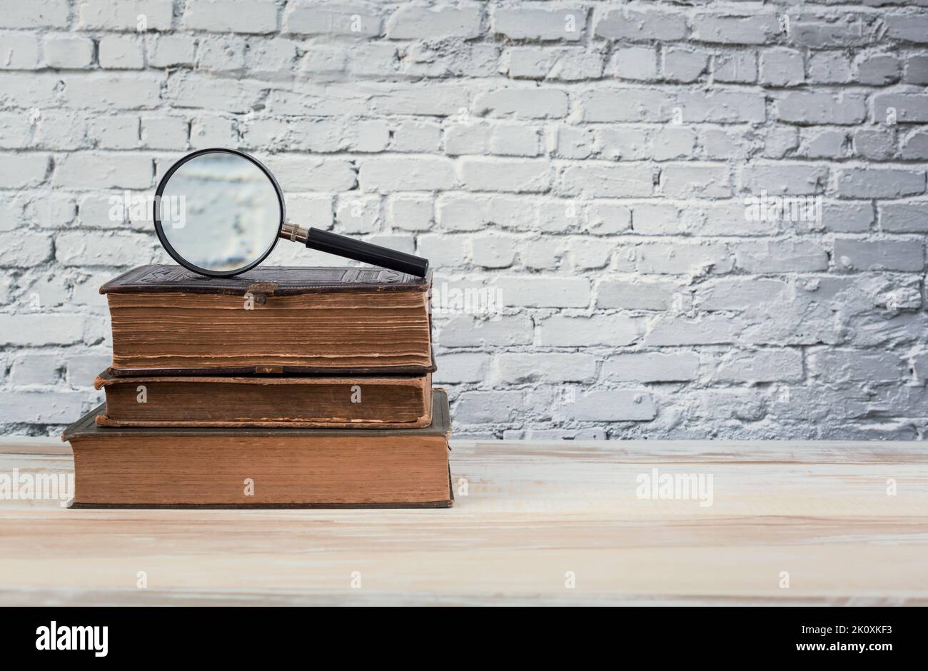 Vintage book and magnifying glass. Concept of education Stock Photo - Alamy