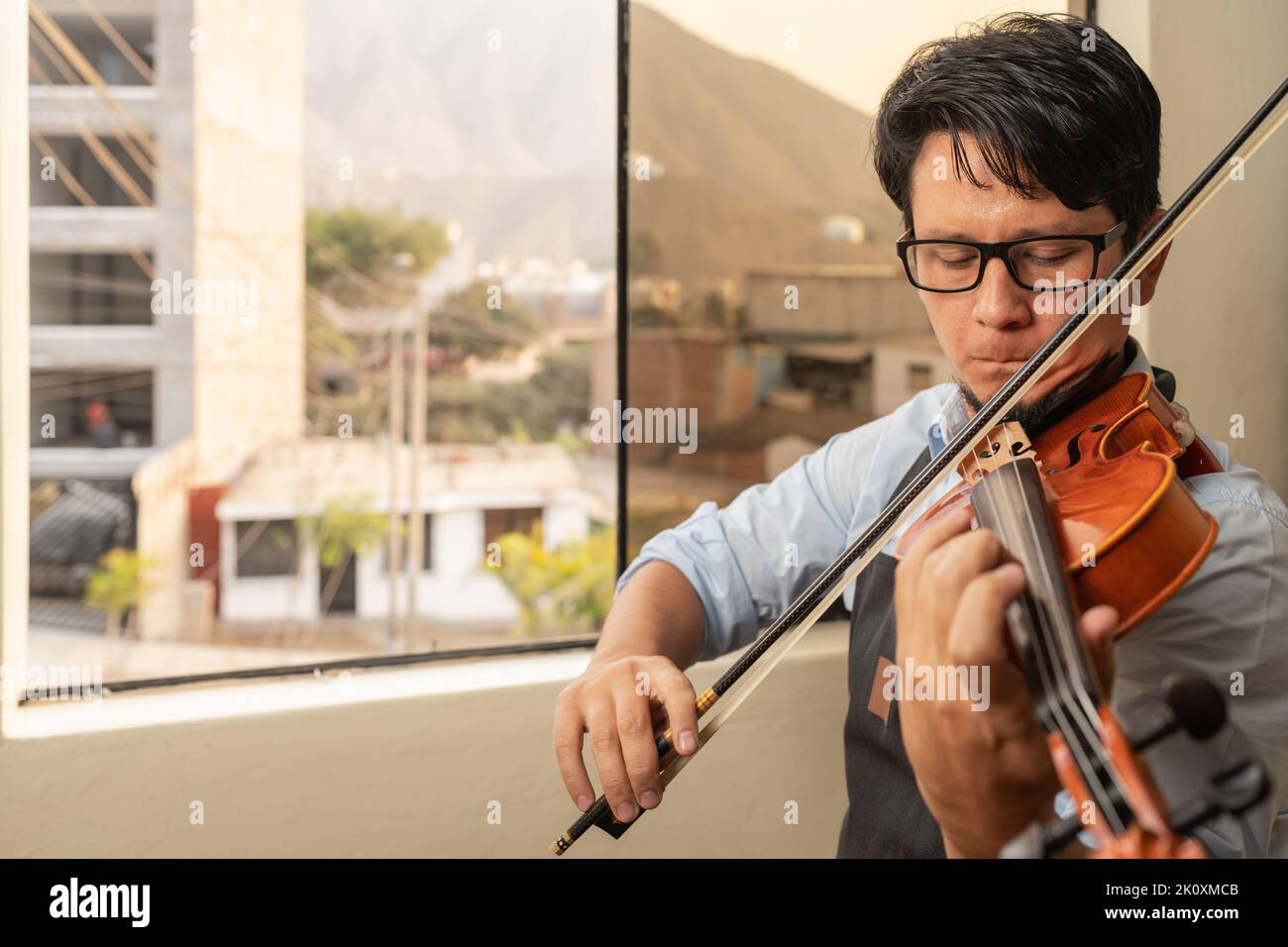 Photo with copy space of a man playing the violin to tuning it in a ...