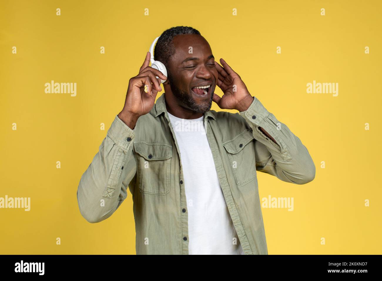 Satisfied mature black man in casual with wireless headphones with ...