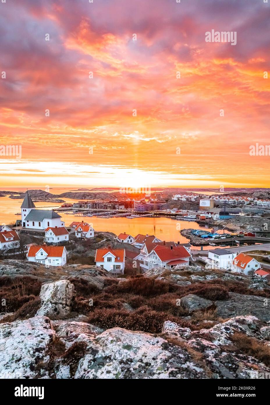 The vertical view of waterside cottage houses under the cloudy sunset ...