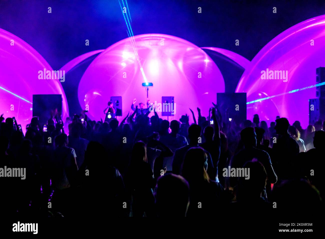 Crowd of unrecognizable people dancing and clapping hands while ...