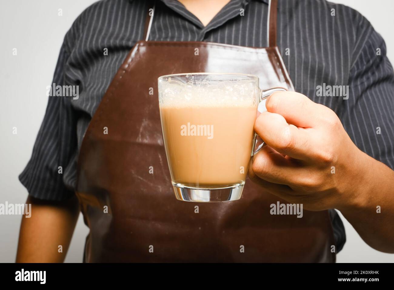 Selective focus picture of hand holding "teh tarik" with men prepared ...