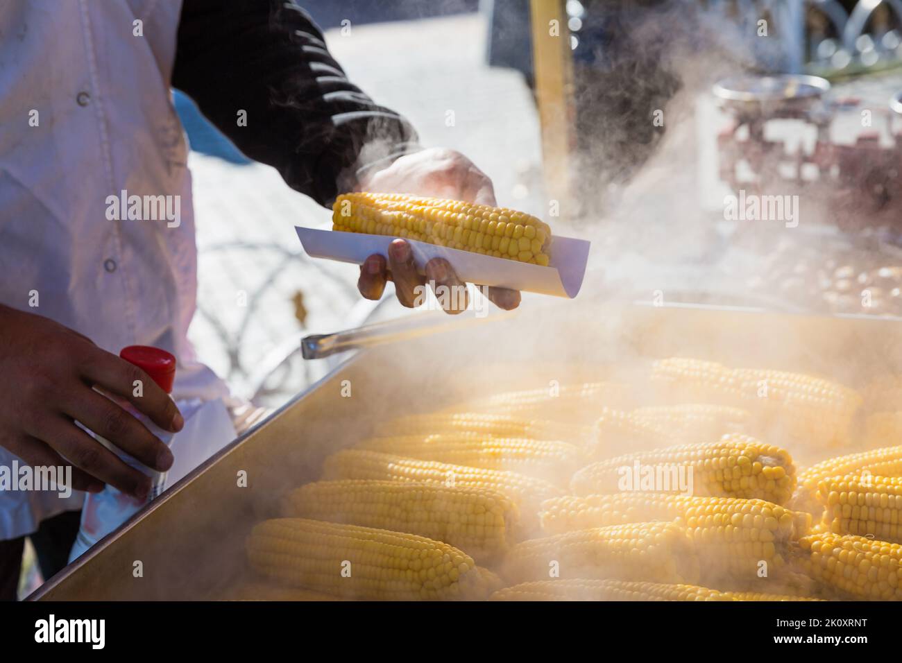 boiled sweet corn for sale on the street in hands of seller. Street ...
