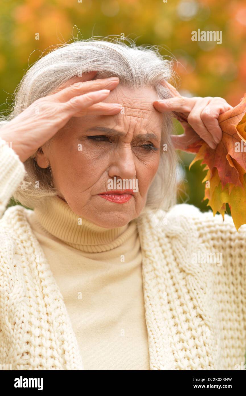 Senior sad woman in the park in autumn Stock Photo - Alamy