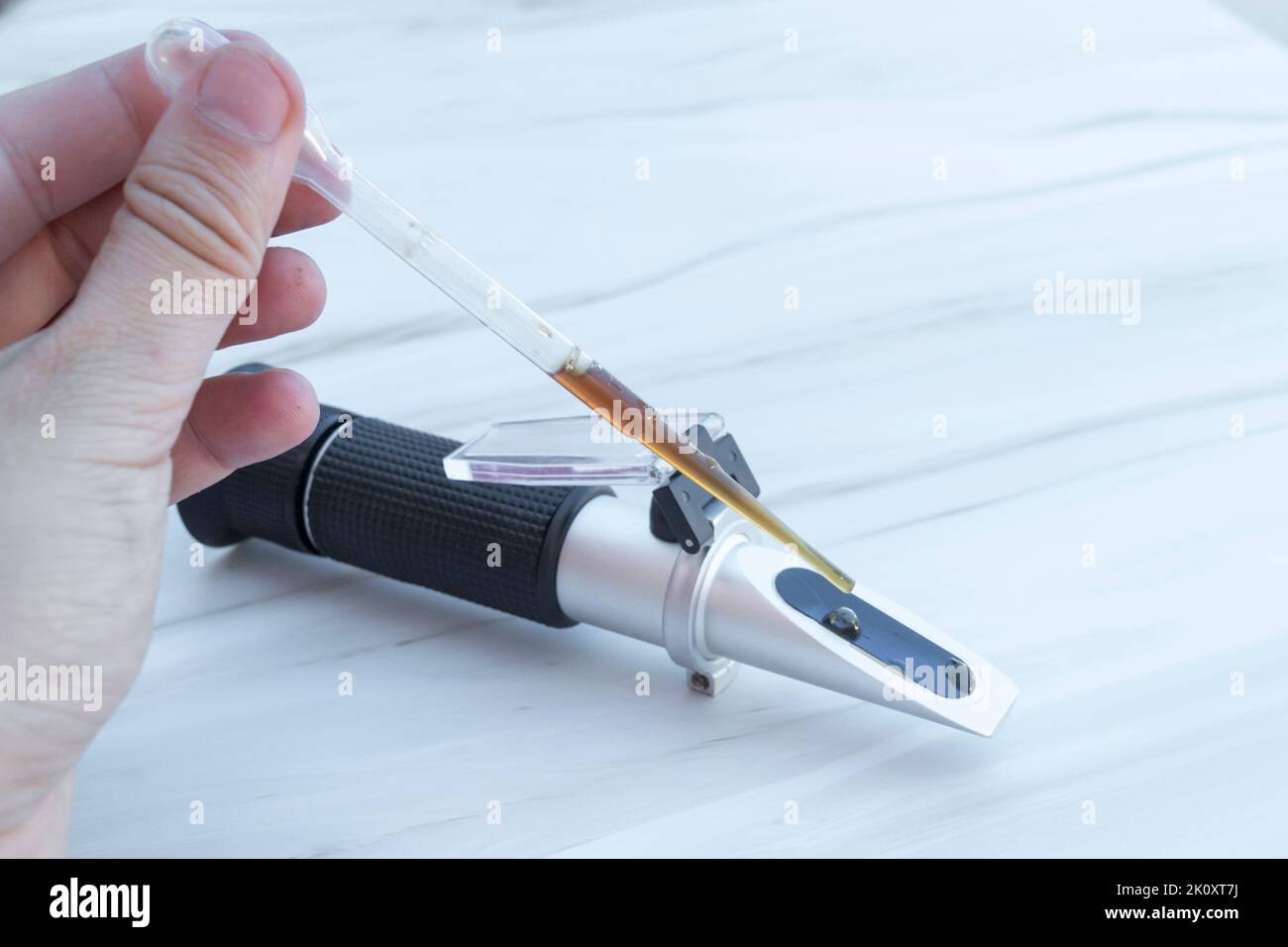 Man using a refractometer device for the measurement of an index of ...