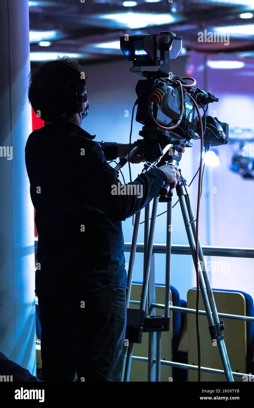 Professional cameraman covering an event. Camera operator silhouette ...