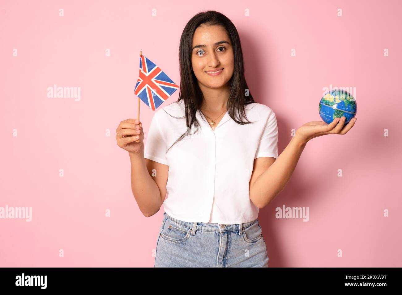 Young hispanic woman holding a united kingdom flag and earth globe ...