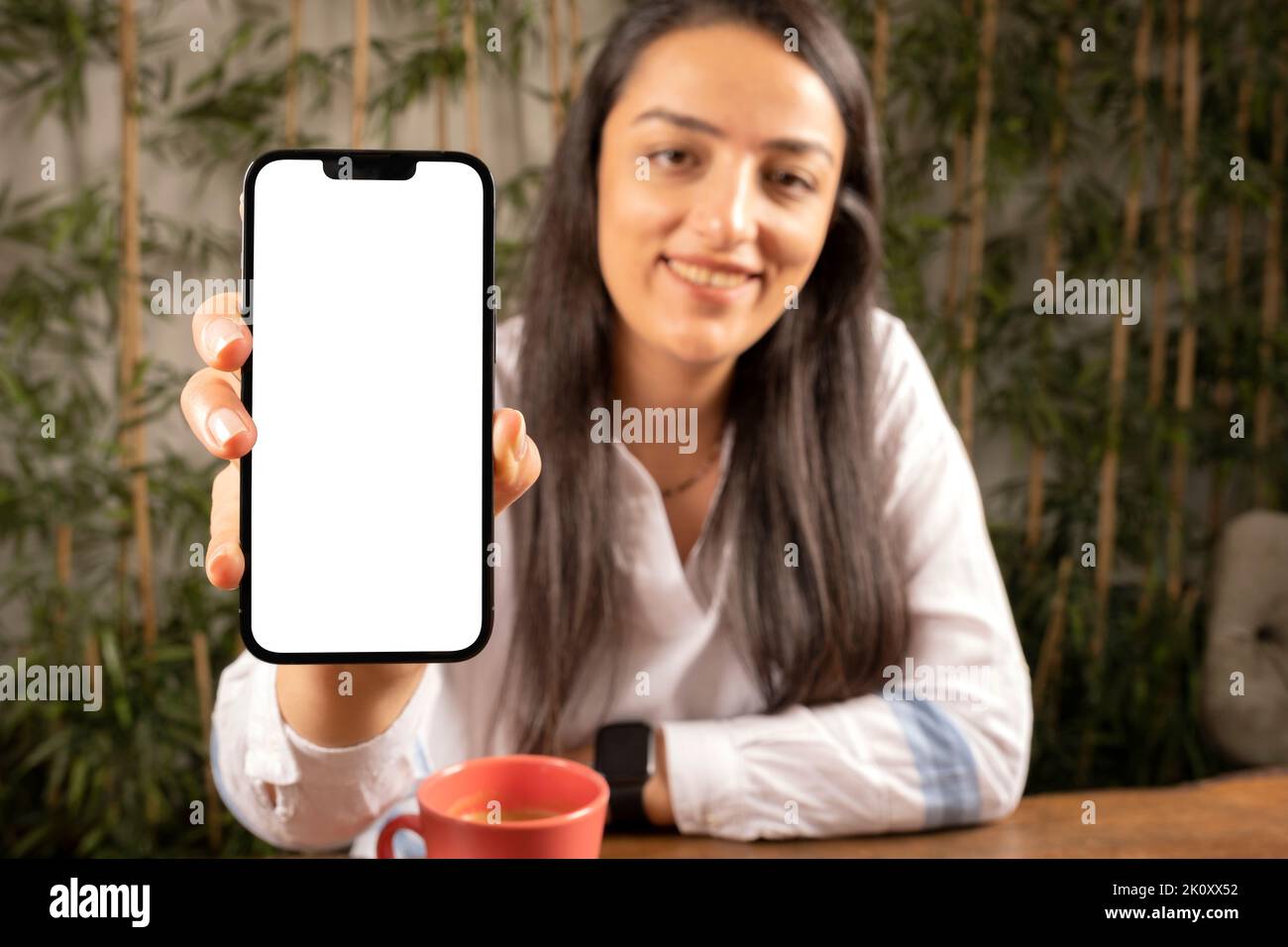 Showing smartphone screen, portrait of young caucasian female showing ...